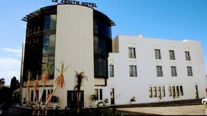 LE ZENITH HOTEL com design moderno, apresentando fachada curva e várias janelas.