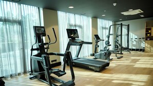 Uma academia com esteiras, elípticos e equipamentos de musculação.