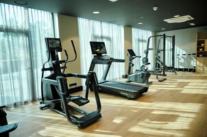 Uma academia com esteiras, elípticos e equipamentos de musculação.