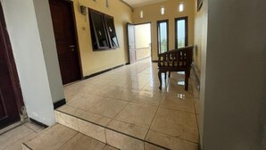 Um corredor com um banco de madeira, soalho em azulejos e portas que dão para outros quartos.