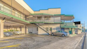Uma garagem com vários andares, uma cobertura e um pequeno edifício com toldo verde.