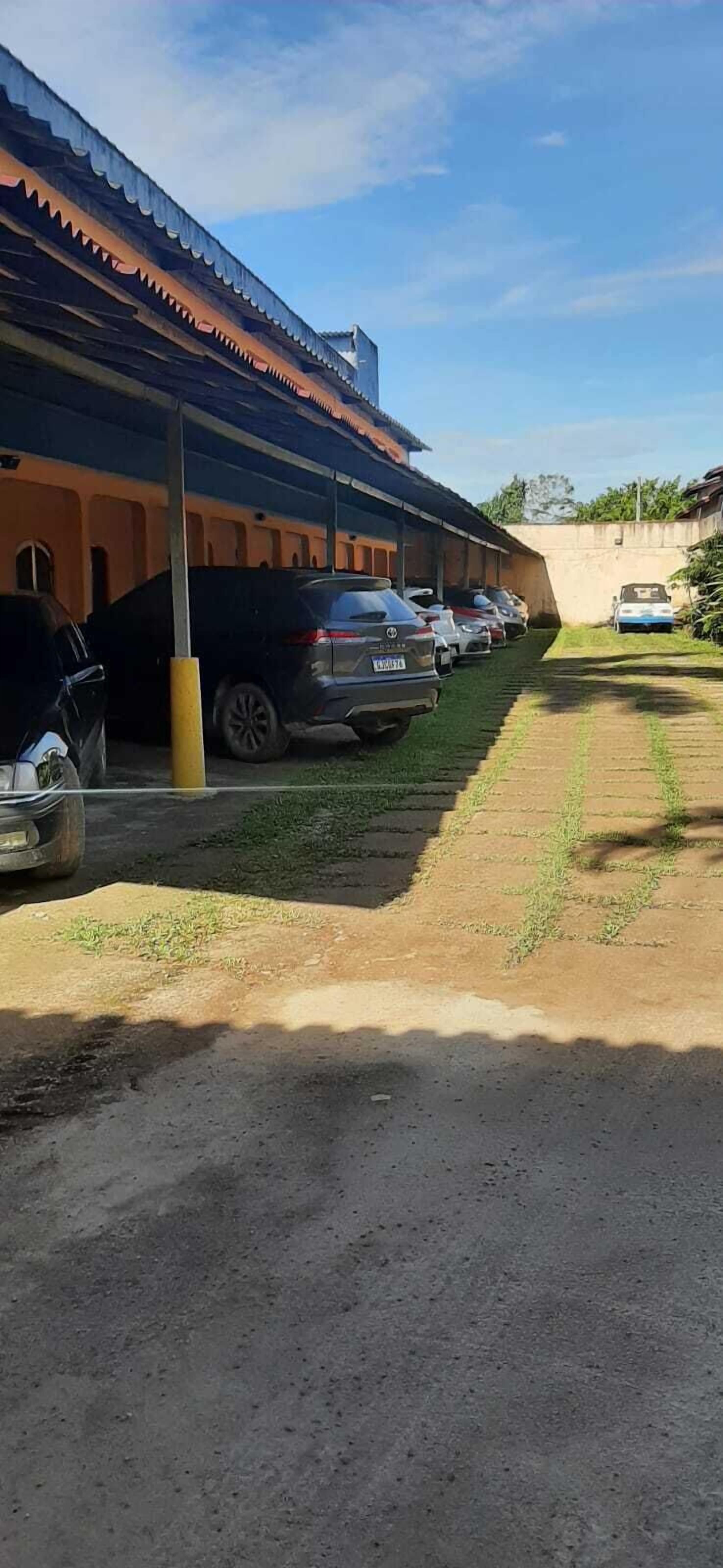 Uma área de estacionamento com vários carros estacionados sob uma cobertura.