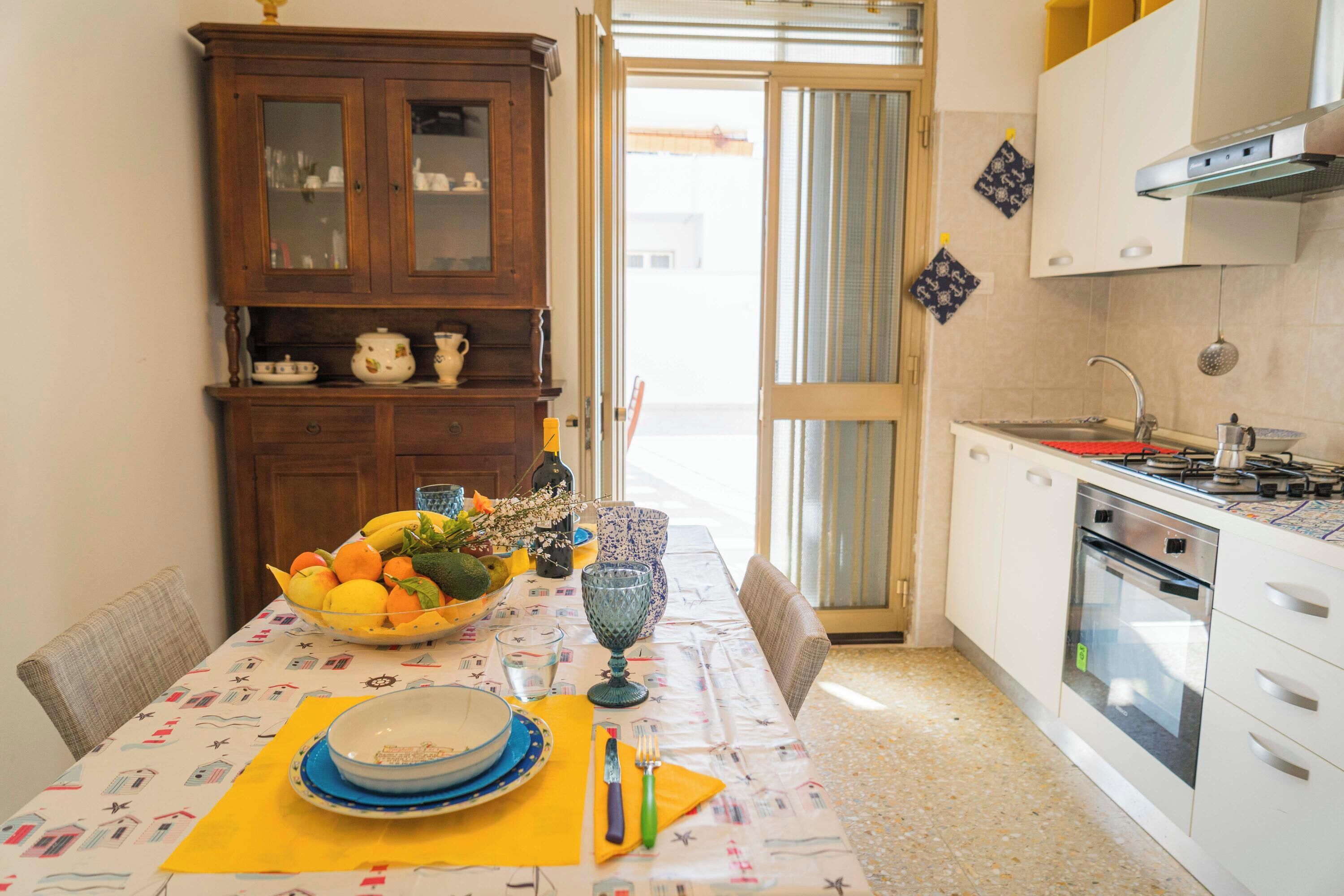 Um frigorífico, um forno, uma placa de cozinha, uma cafeteira/bule 