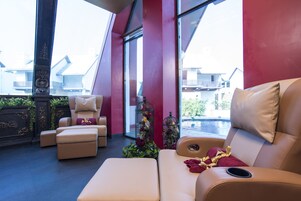 Uma área de estar moderna com um sofá, poltronas e uma pequena mesa.
