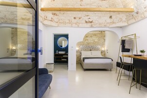 Quarto moderno com cama beliche, escrivaninha com cadeira e banheiro com espelho redondo.