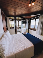Um quarto com cama, mesa e televisão.
