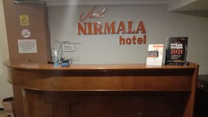 Bancada de recepção no hotel Nirmala com uma placa indicando o ano de 2021.