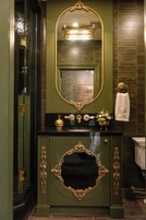 Casa de banho com espelho, lavatório e porta-toalhas.