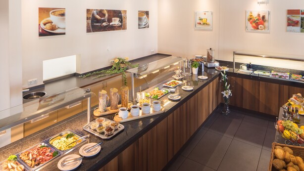 Disposição de buffet com diversos alimentos e um espaço para café.
