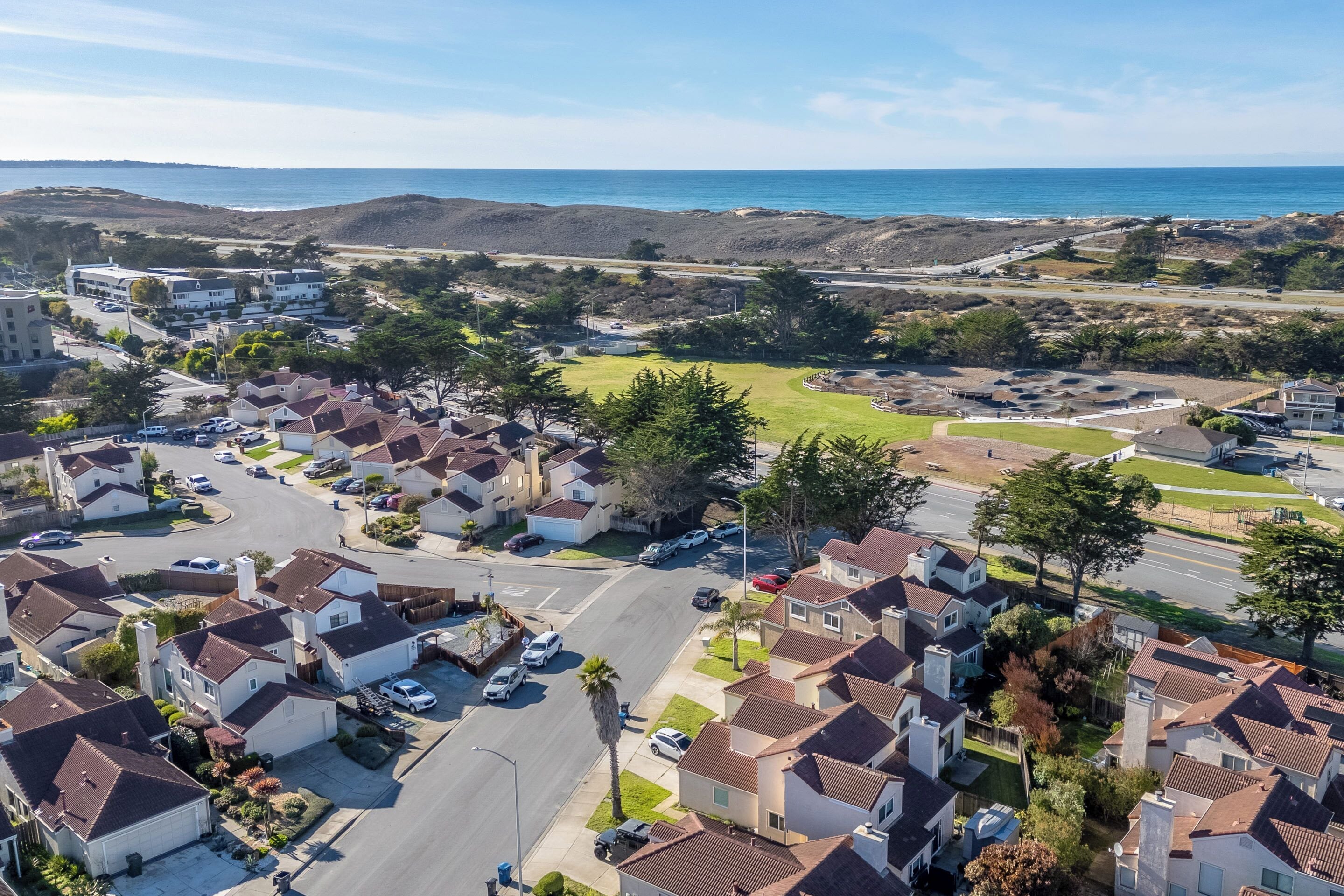 Bairro residencial com casas, ruas e vista para o mar.