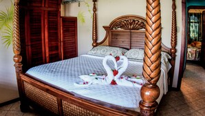 Uma cama de dossel com cabeceira de tear, colcha floral e arranjo decorativo de cisnes.