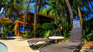 Uma área de piscina com espreguiçadeiras e uma placa indicando o Hotel Mareriva.