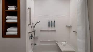 Uma casa de banho moderna com banheira, chuveiro e um porta-toalhas de madeira.