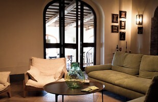 Uma sala de estar acolhedora com um sofá, uma poltrona e uma mesa de centro com um vaso.