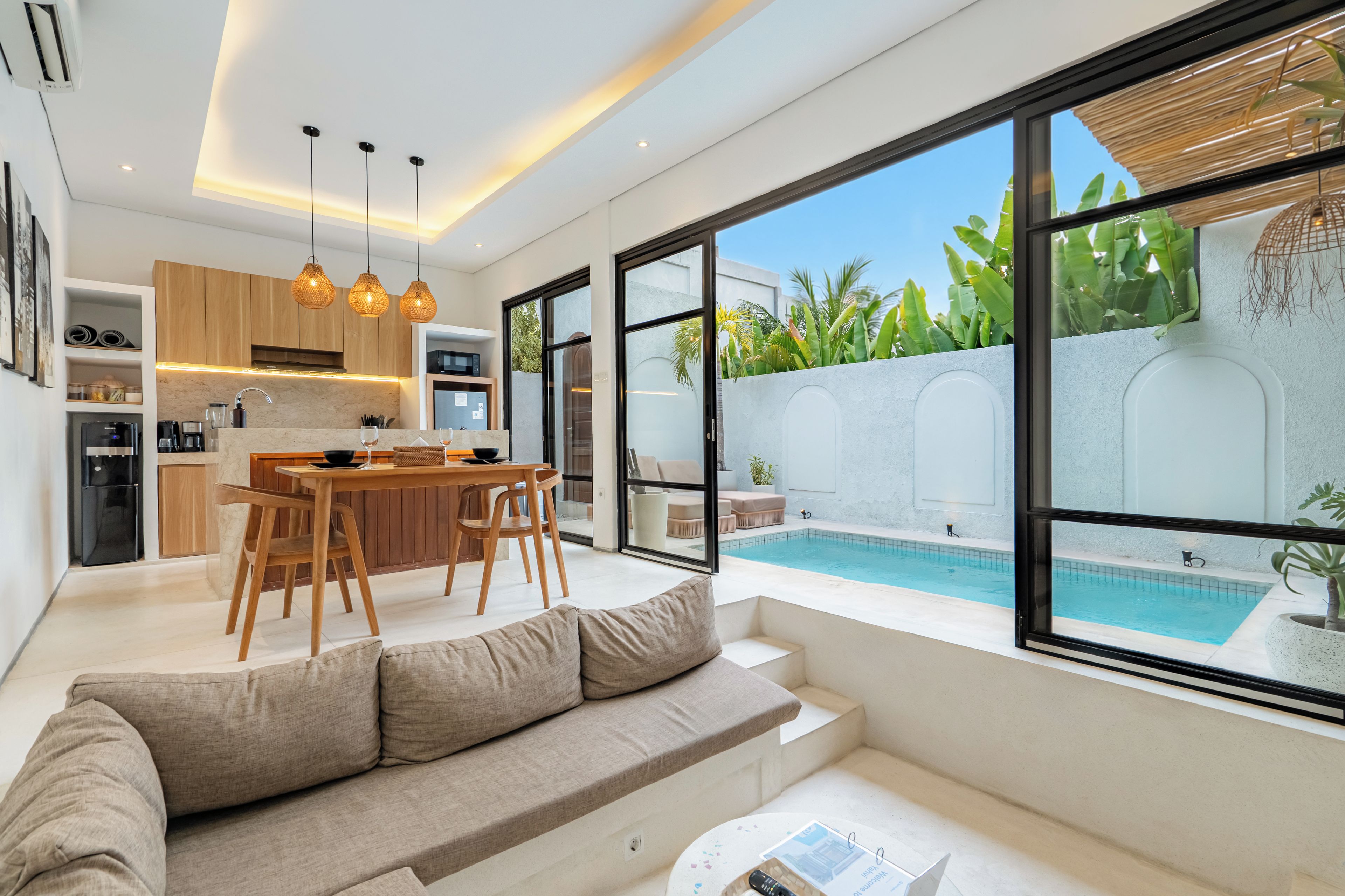 Decoração moderna com área de refeições, cozinha e espaço para sentar junto à piscina.