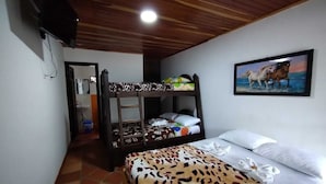 Quarto com beliche, uma cama de solteiro, pintura de cavalos e piso ladrilhado.