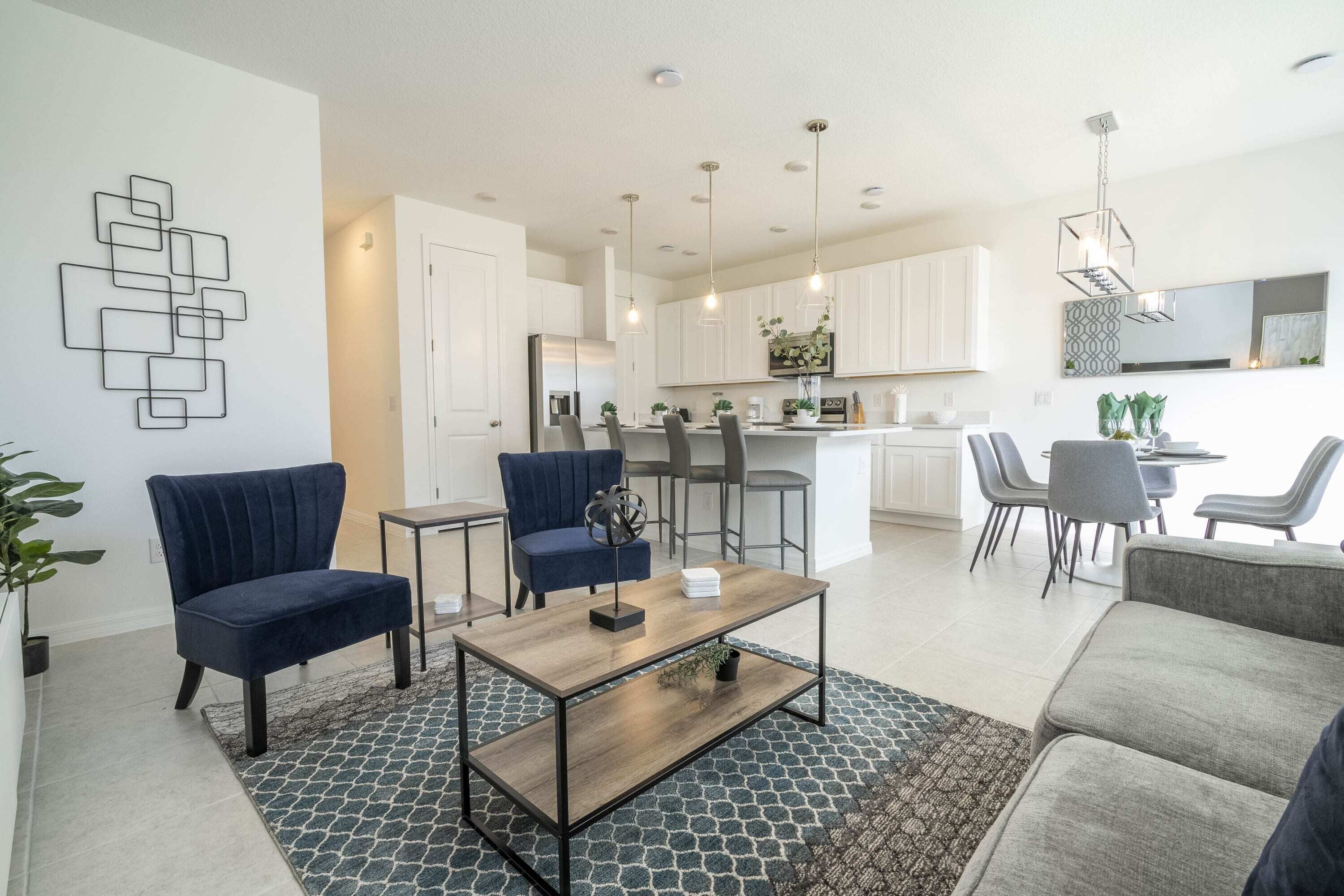 Uma sala de estar moderna com um sofá, uma mesa de centro e um espaço de refeições com cadeiras e uma mesa.