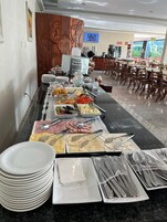 Disposição de buffet com diversos alimentos e utensílios.