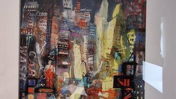 Uma pintura abstrata emoldurada com elementos urbanos e texto.