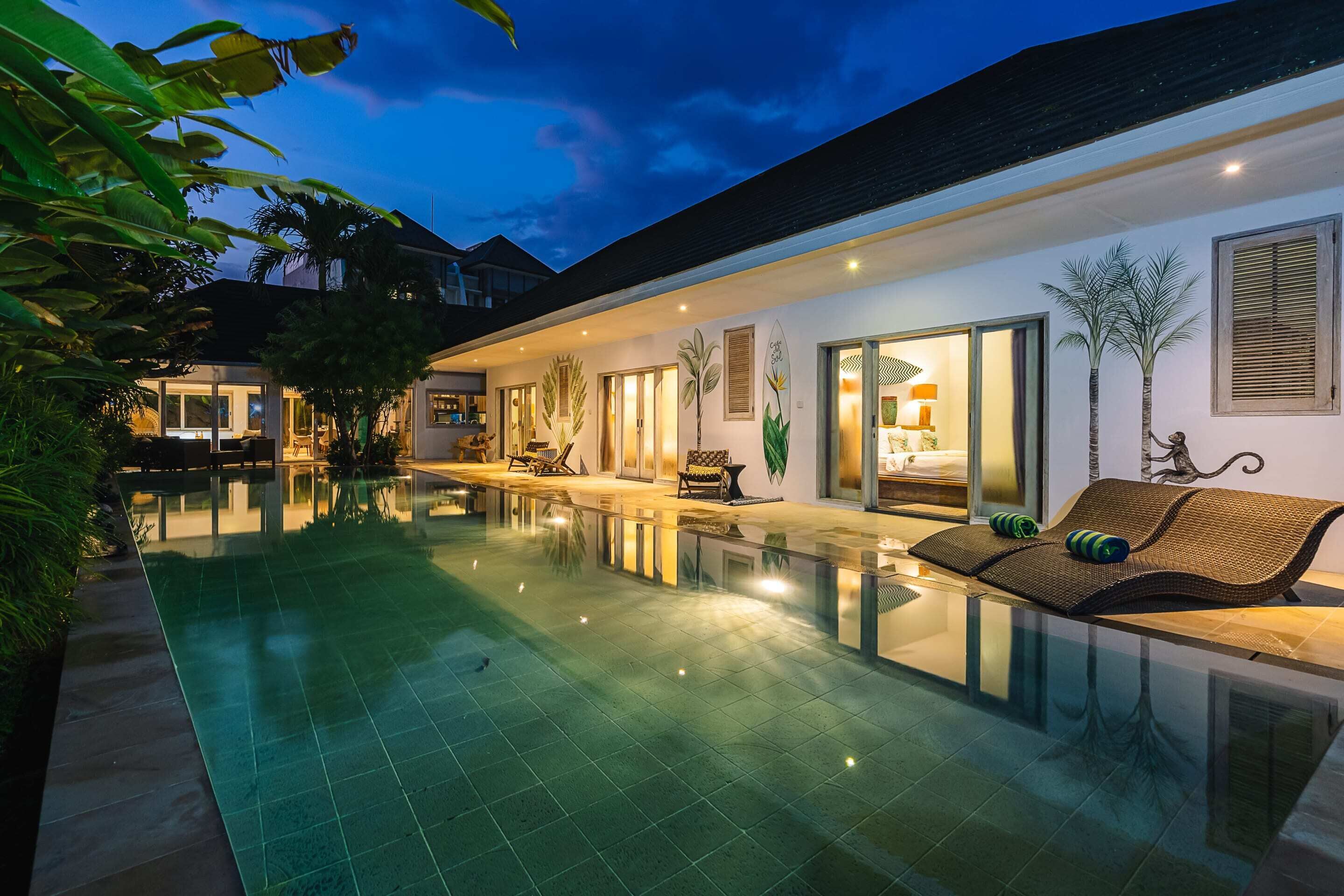 Uma casa moderna com piscina, área de estar externa e interior bem iluminado.