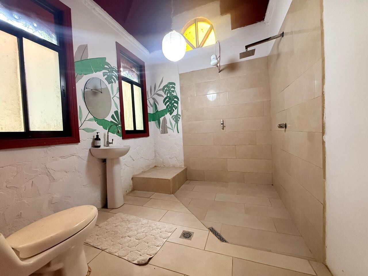 Casa de banho com sanita, lavatório e zona de duche.