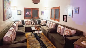 Uma sala de estar com dois sofás, uma mesa de centro e um lustre.