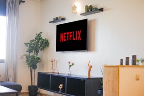 Apartamento Básico, Vista para a cidade | Sala de estar | Smart TV de 55 polegadas com canais via satélite, filmes pagos