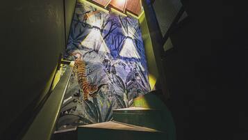 Uma escadaria com um mural de uma onça e uma cena de floresta.
