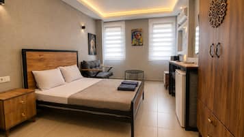 Quarto moderno com cama, mesa de cabeceira, guarda-roupa e um pequeno espaço de trabalho.