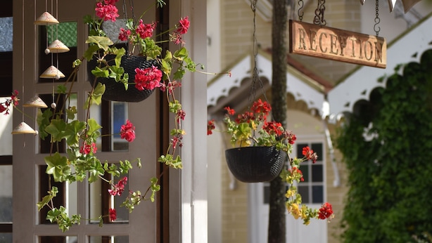 Uma área de recepção com uma cesta de flores pendurada e uma placa com a inscrição 'RECEPTION'.