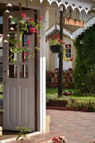 Uma área de recepção com uma cesta de flores pendurada e uma placa com a inscrição 'RECEPTION'.