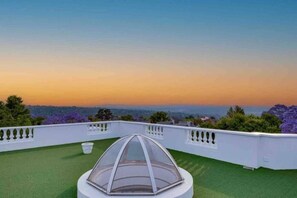 Terraço no telhado com vista clara do horizonte da cidade ao pôr do sol.