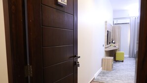 Um corredor com uma porta de madeira com a placa '203'.