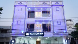 Um hotel chamado Blossom Inn, com uma placa, entrada com portão e varanda com grades.