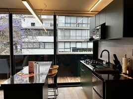 Cozinha moderna com uma janela ampla, fogão embutido e uma pia.