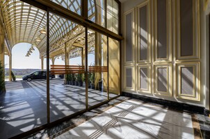 Um hall amplo com teto alto e janelas grandes, permitindo que a luz natural ilumine o espaço.