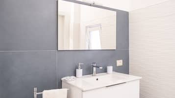 Quarto Duplo Deluxe | Casa de banho | Um polibã, um chuveiro fixo, um secador de cabelo, chinelos