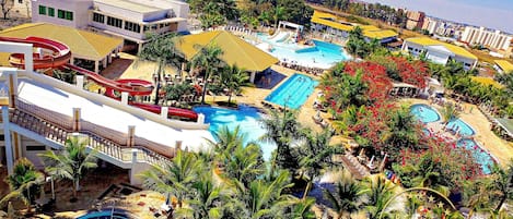 Resort com várias piscinas, toboáguas e palmeiras.