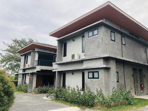 Um edifício moderno de dois andares com telhado plano e fachada de concreto.
