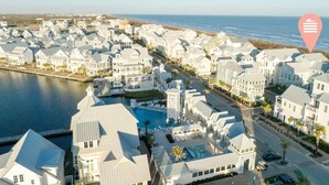 Zona residencial à beira-mar com casas brancas, um porto de iates e uma piscina grande.