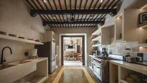 Uma cozinha moderna com ilha central, eletrodomésticos embutidos e piso em azulejo.