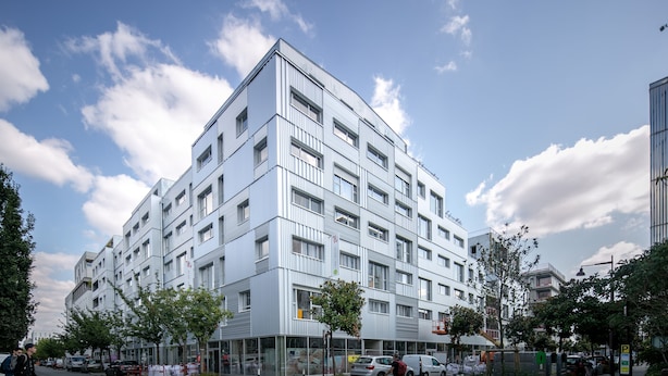 Um edifício moderno de vários andares com fachada de vidro, provavelmente um hotel ou edifício de escritórios, com design simétrico e diversas janelas.