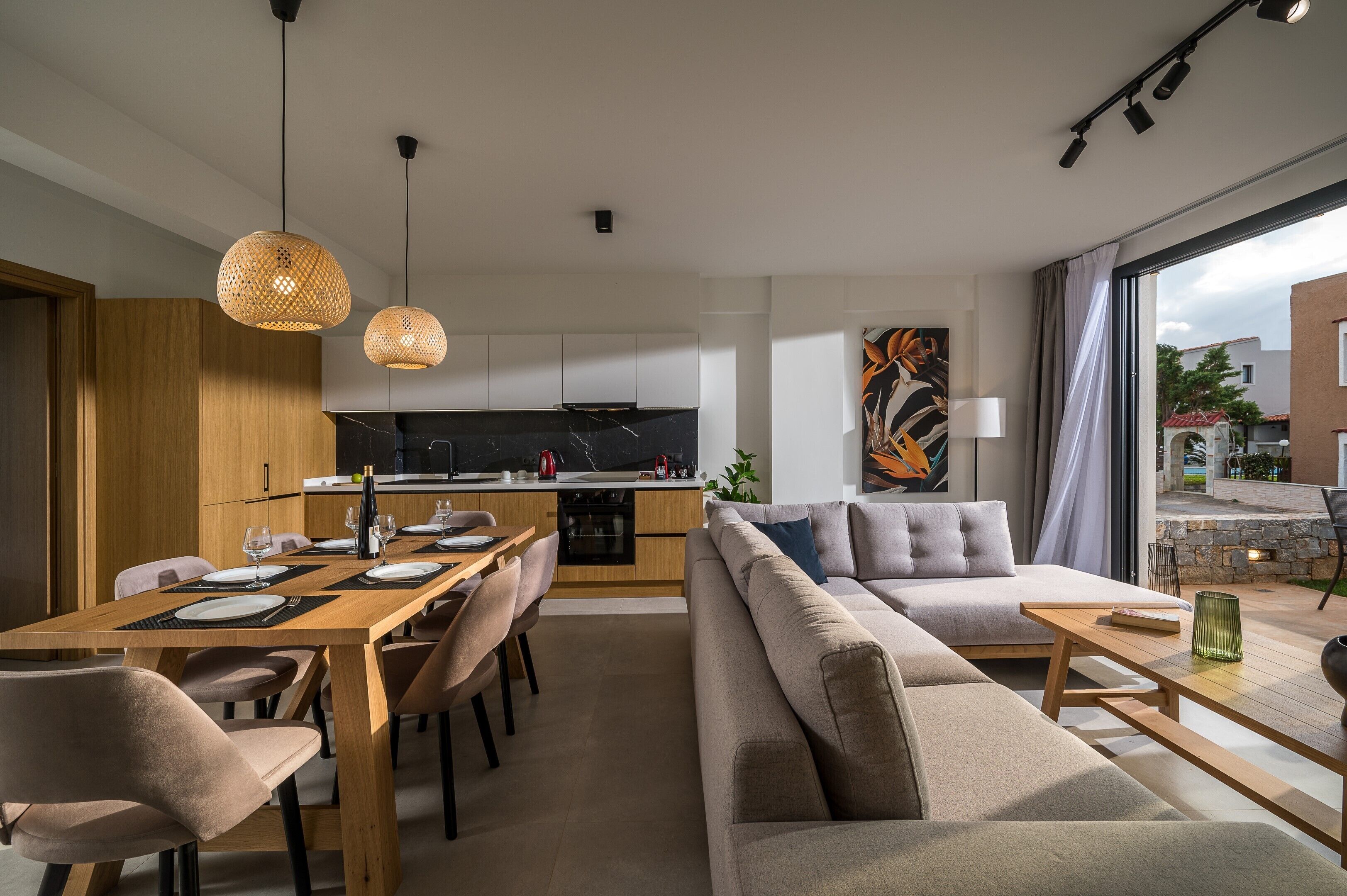Uma sala de estar moderna com sofá, mesa de jantar e cozinha.