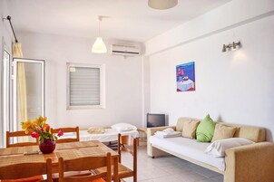 Apartamento família, vista para o mar | Área de estar | TV de tela plana
