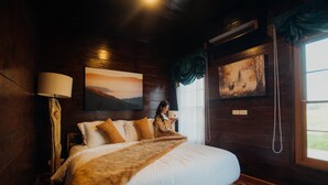 Um quarto aconchegante com uma cama grande, uma luminária e um quadro na parede.
