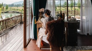 Um canto aconchegante para leitura com vista para um lago e montanhas.