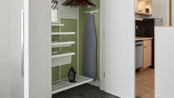 Quarto compacto com roupeiro, tábua de passar e cozinha compacta.