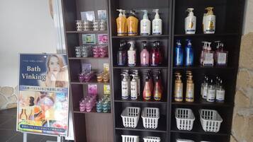 Casa de banho com prateleiras repletas de produtos de higiene e banho.