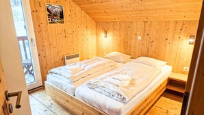 Quarto com painéis de madeira, duas camas, uma janela e uma porta.