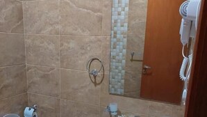 Casa de banho com sanita, lavatório e zona de chuveiro.